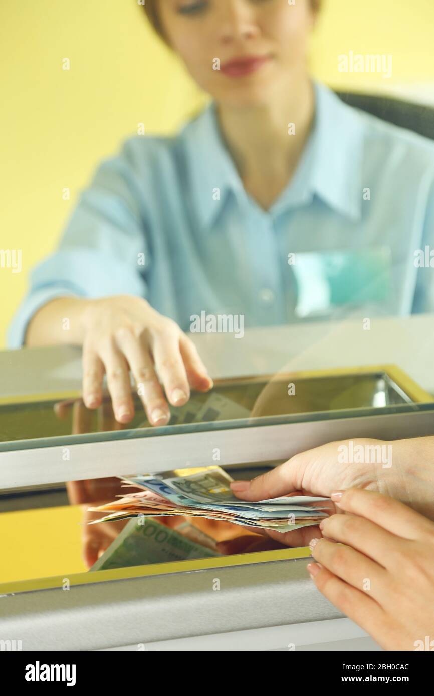 Teller window with working cashier Stock Photo - Alamy