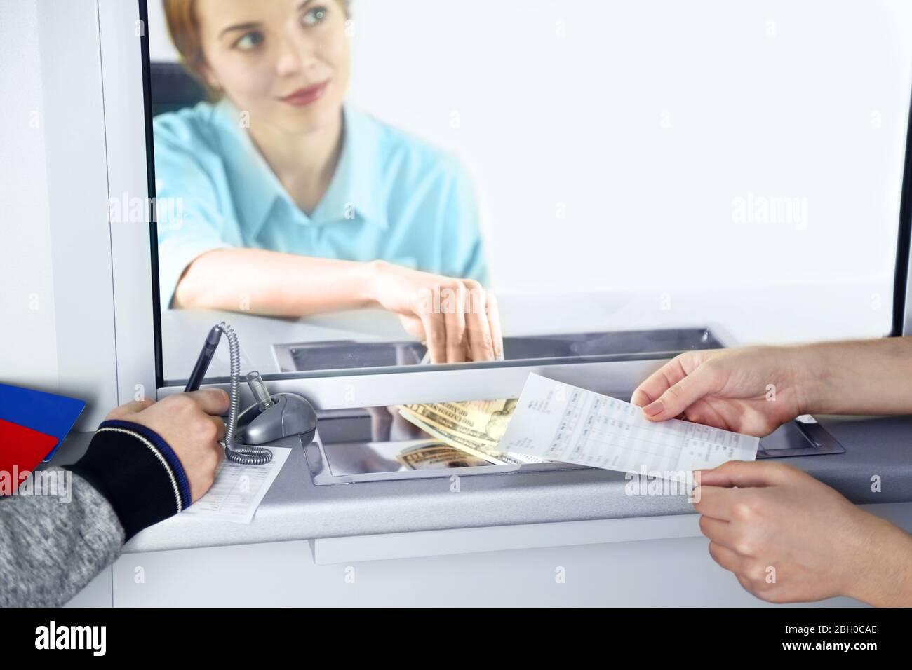 Teller window with working cashier Stock Photo - Alamy