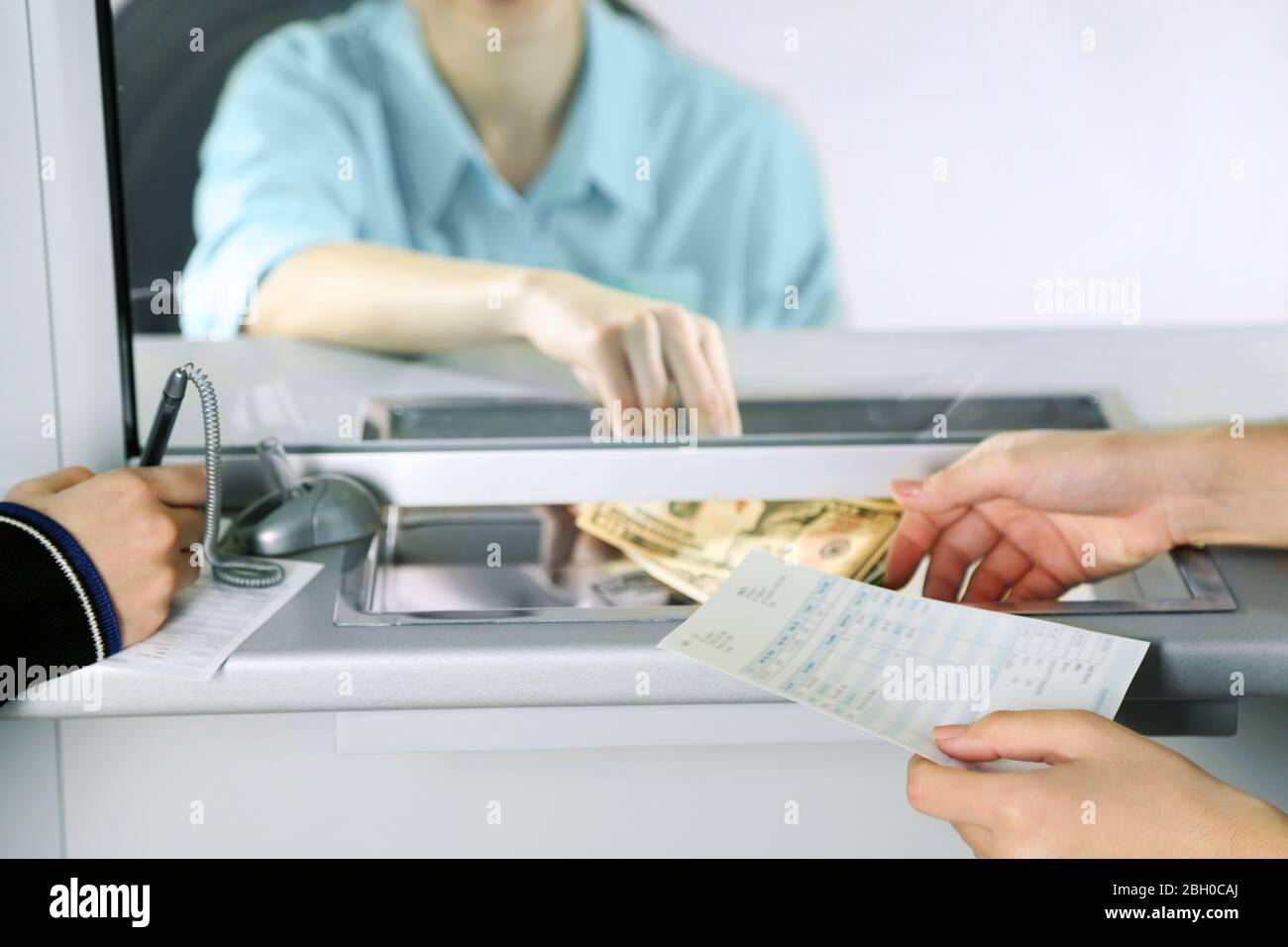 Teller window with working cashier Stock Photo - Alamy