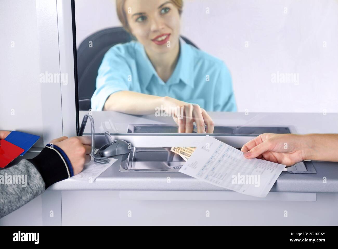 Teller window with working cashier Stock Photo - Alamy
