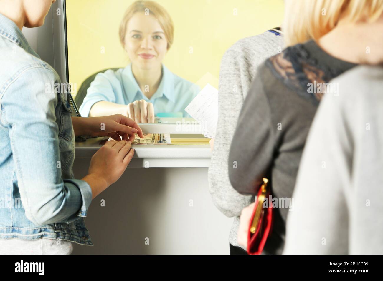 Teller window with working cashier Stock Photo - Alamy