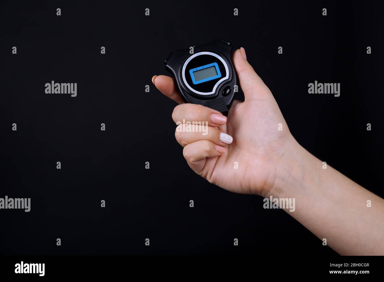 Electronic sport timer in female hand on black background Stock Photo ...
