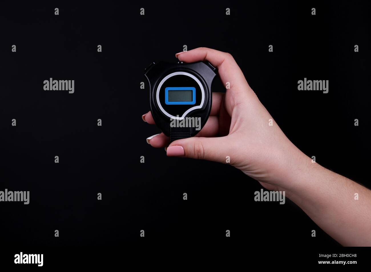 Electronic sport timer in female hand on black background Stock Photo ...
