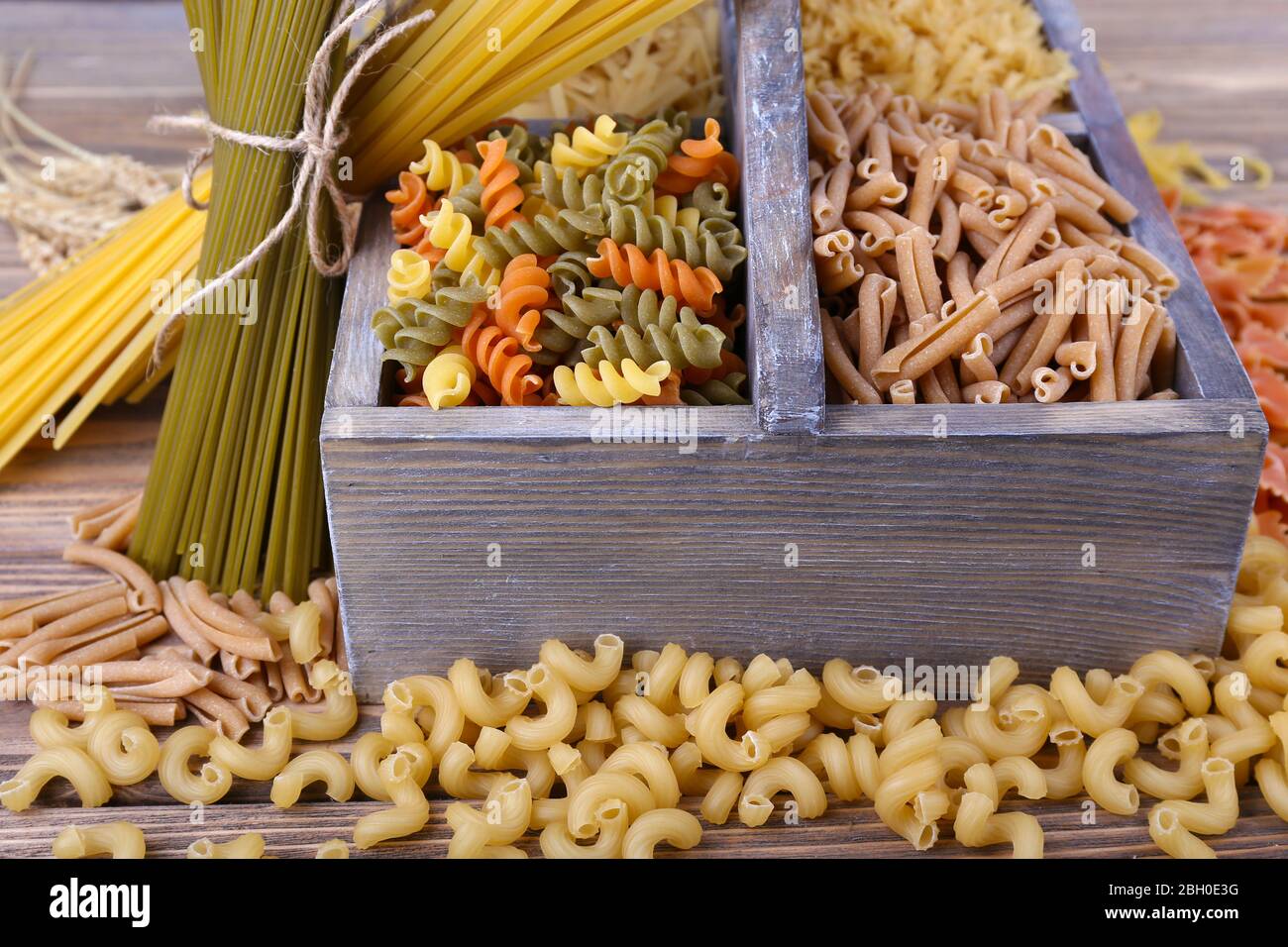 Different types of pasta in box on wooden background Stock Photo - Alamy