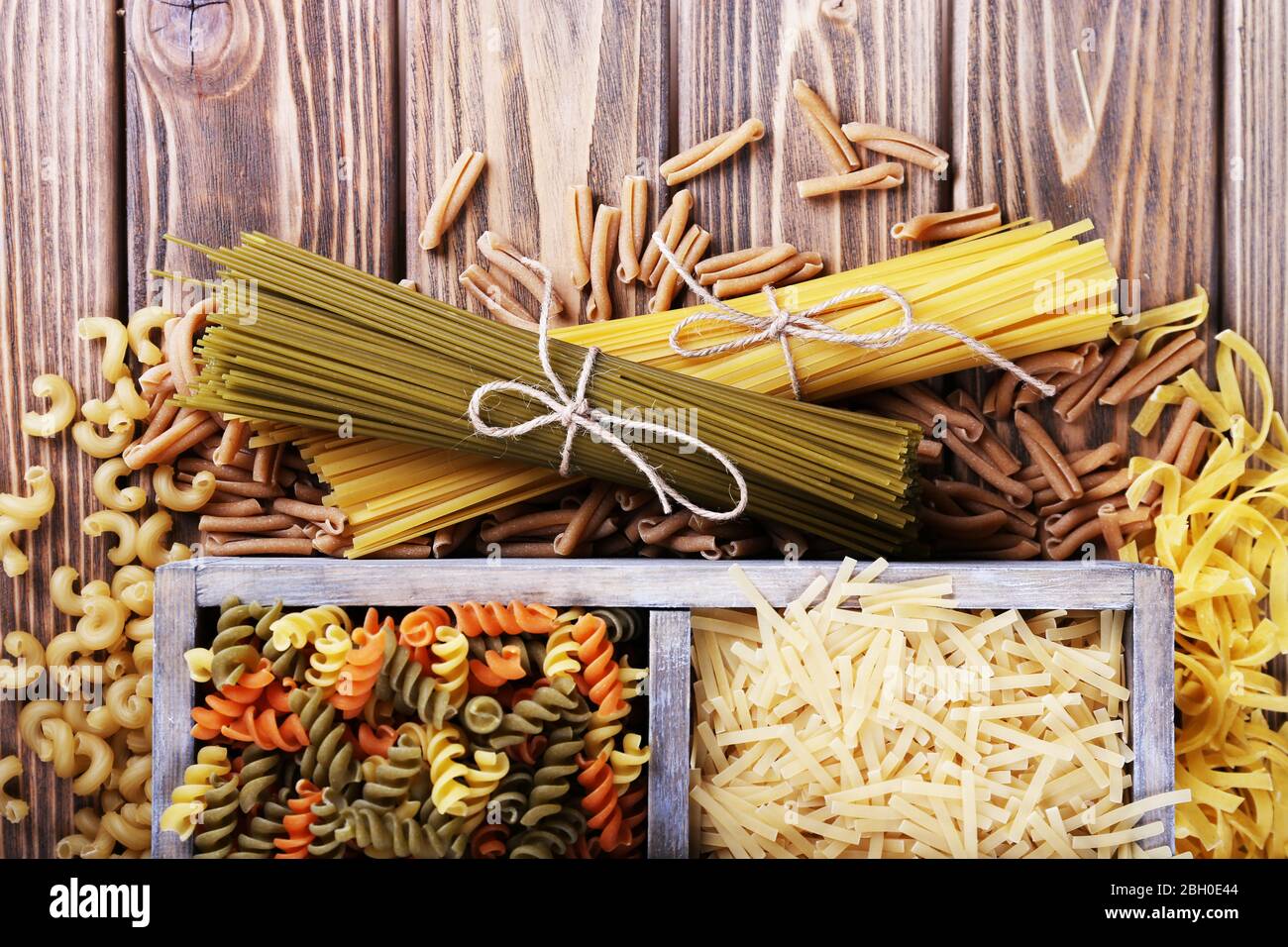 Different types of pasta in box on wooden background Stock Photo - Alamy