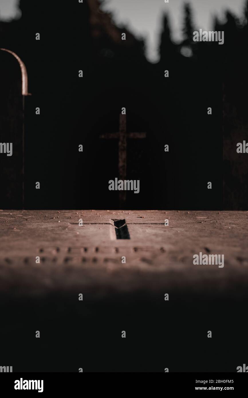 Dark underexposed image of a tombstone. Shallow depth of field focus on ...