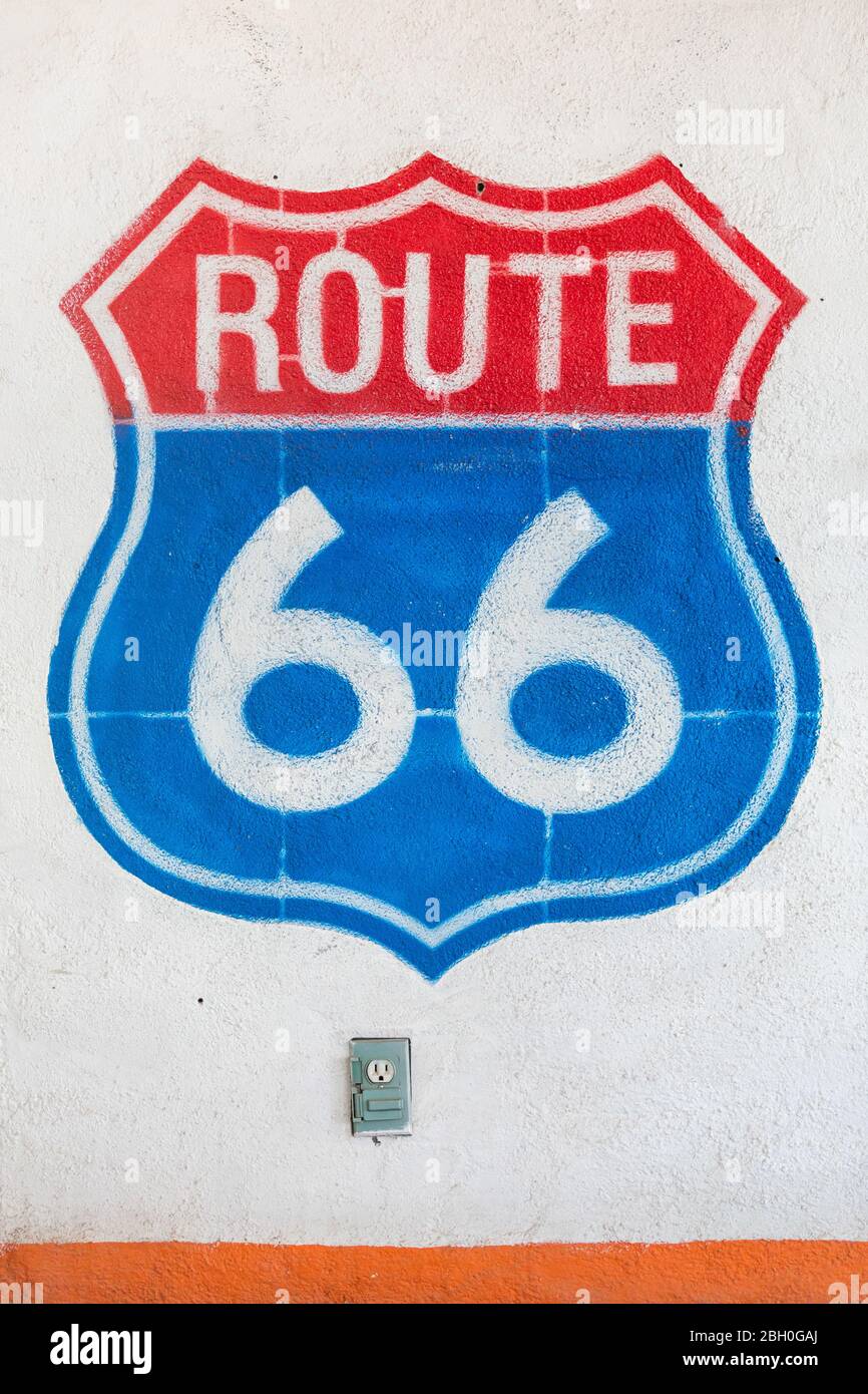 Close up of red and blue Route 66 badge painted on a white plaster wall ...