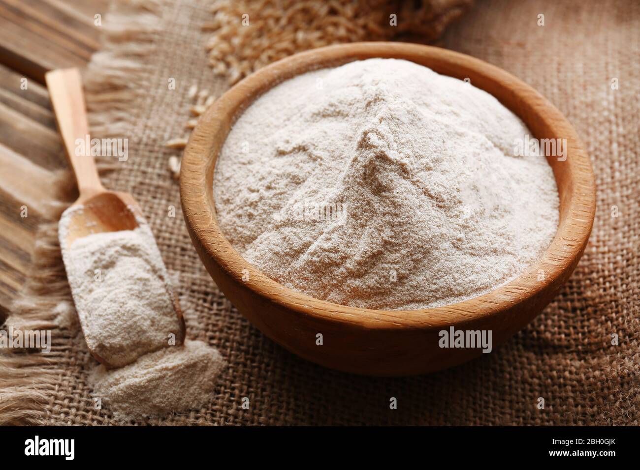 Flour in bowl with grains in bag on sackcloth background Stock Photo ...