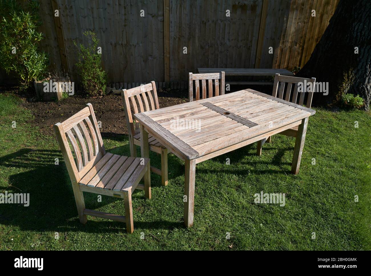 Iroko table and chairs in an english garden on an early spring sunny ...