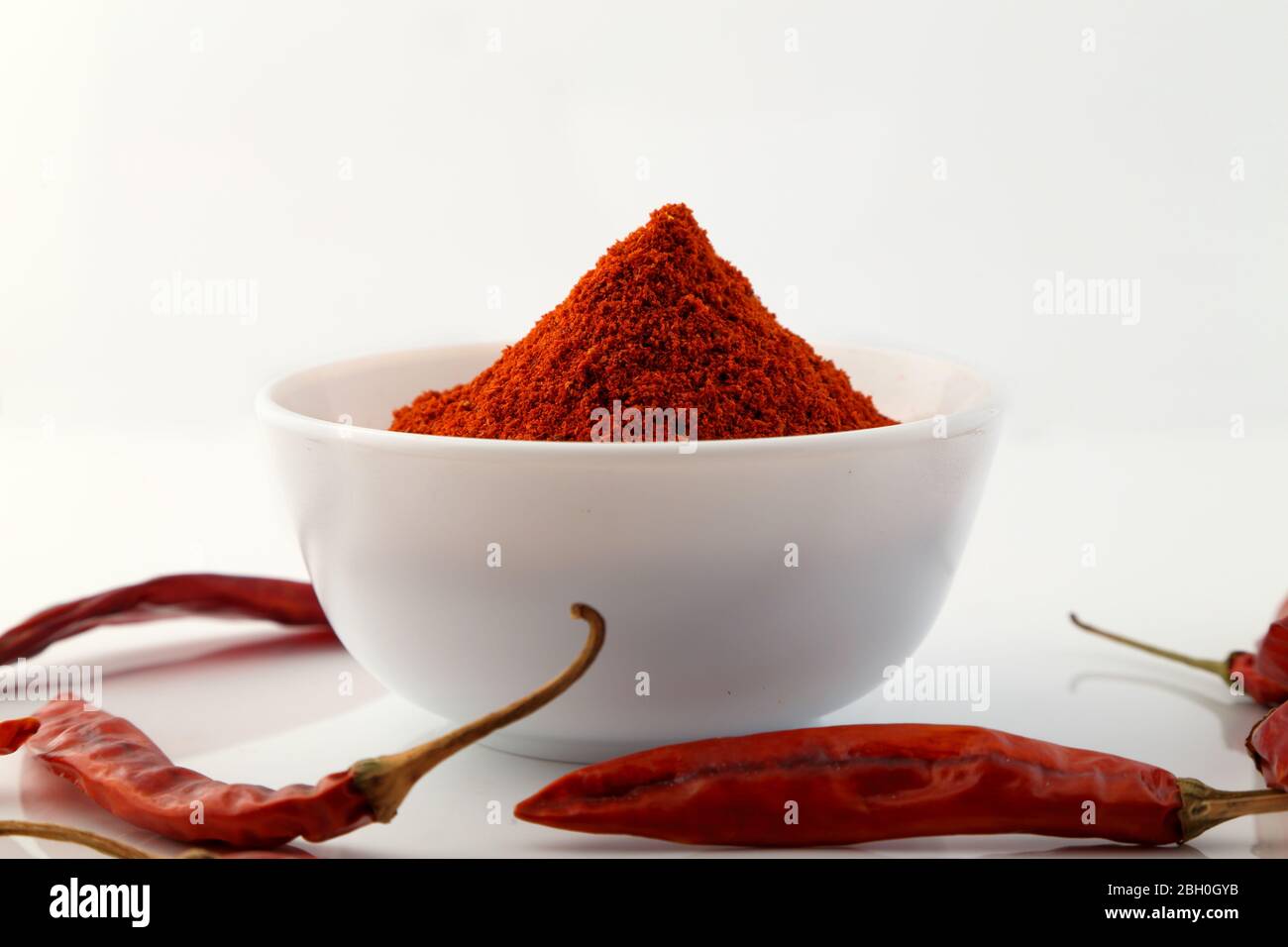 red chillies with red chilly powder on white background Stock Photo - Alamy