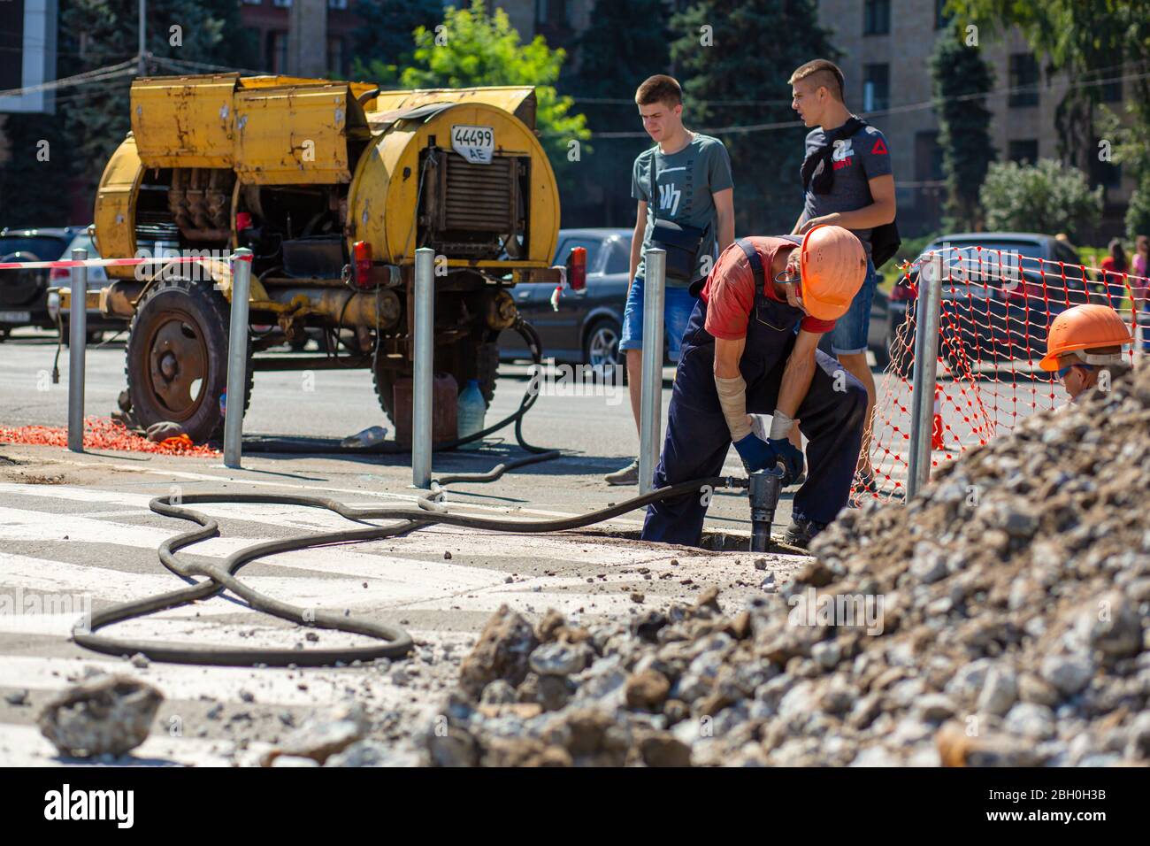 Repair work on the city street. Professional workers dismantle part of ...