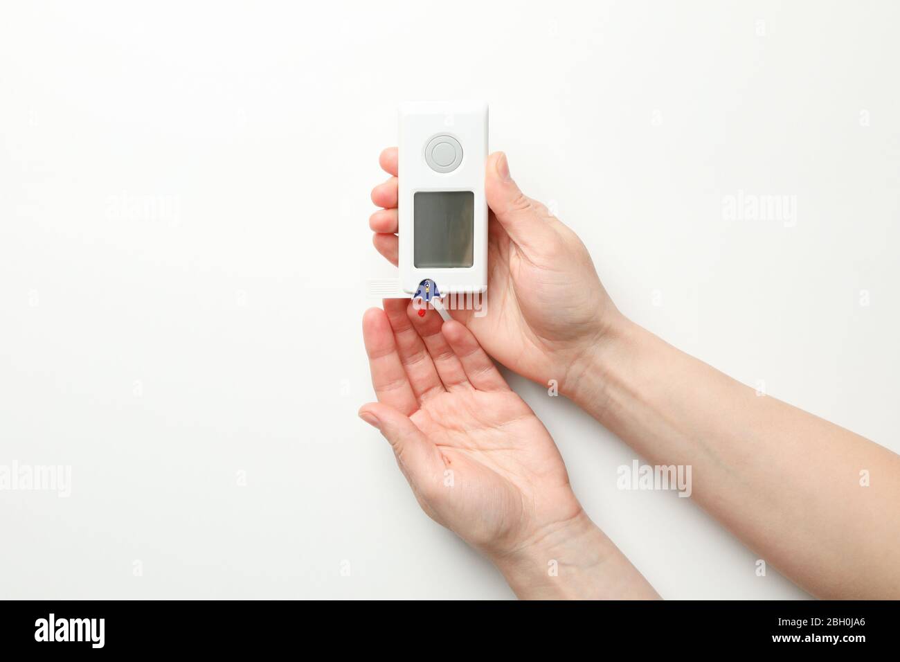 Female checking blood sugar level on white background Stock Photo - Alamy