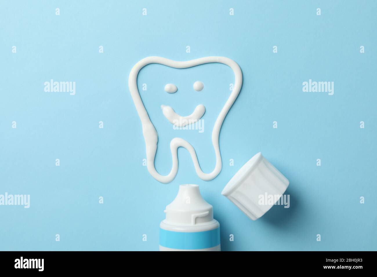 Tooth made of toothpaste and tube on blue background, top view Stock ...