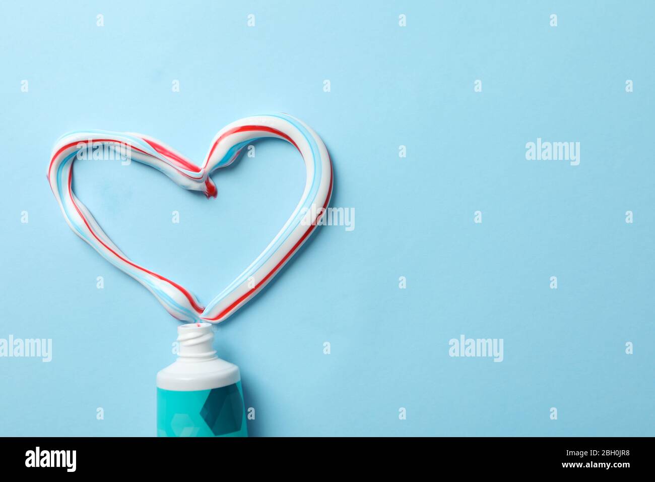 Heart made of toothpaste and tube on blue background, top view Stock ...