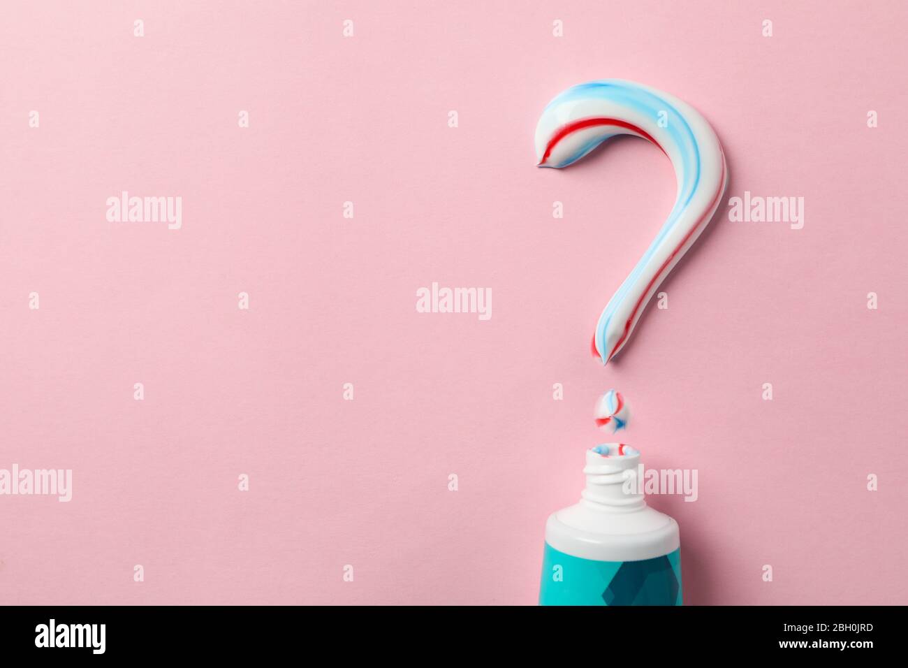 Question mark made of toothpaste and tube on pink background, copy ...