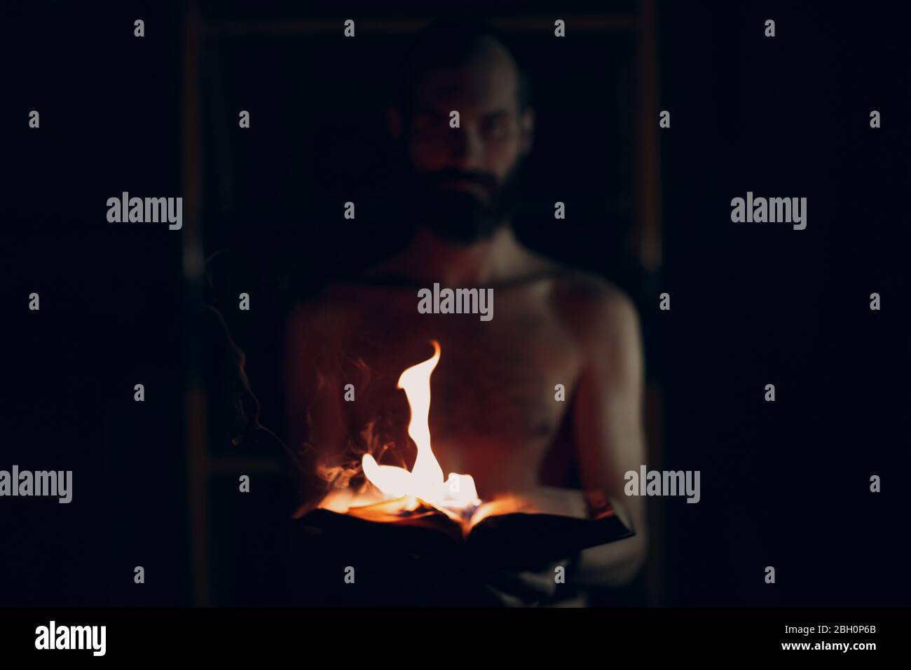 Man holds burning book in his hands Stock Photo - Alamy
