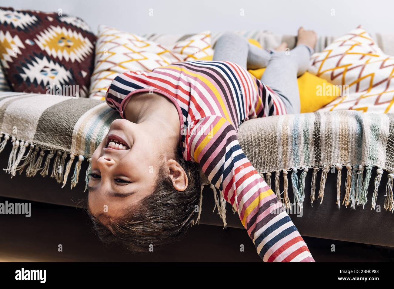 funny little girl laughs happy lying on the couch, concept of children ...