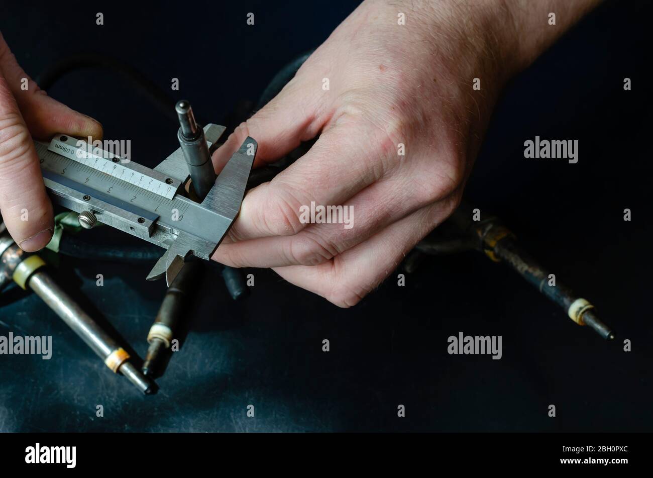 Auto mechanic repairs fuel diesel injectors. The hands of an adult male ...
