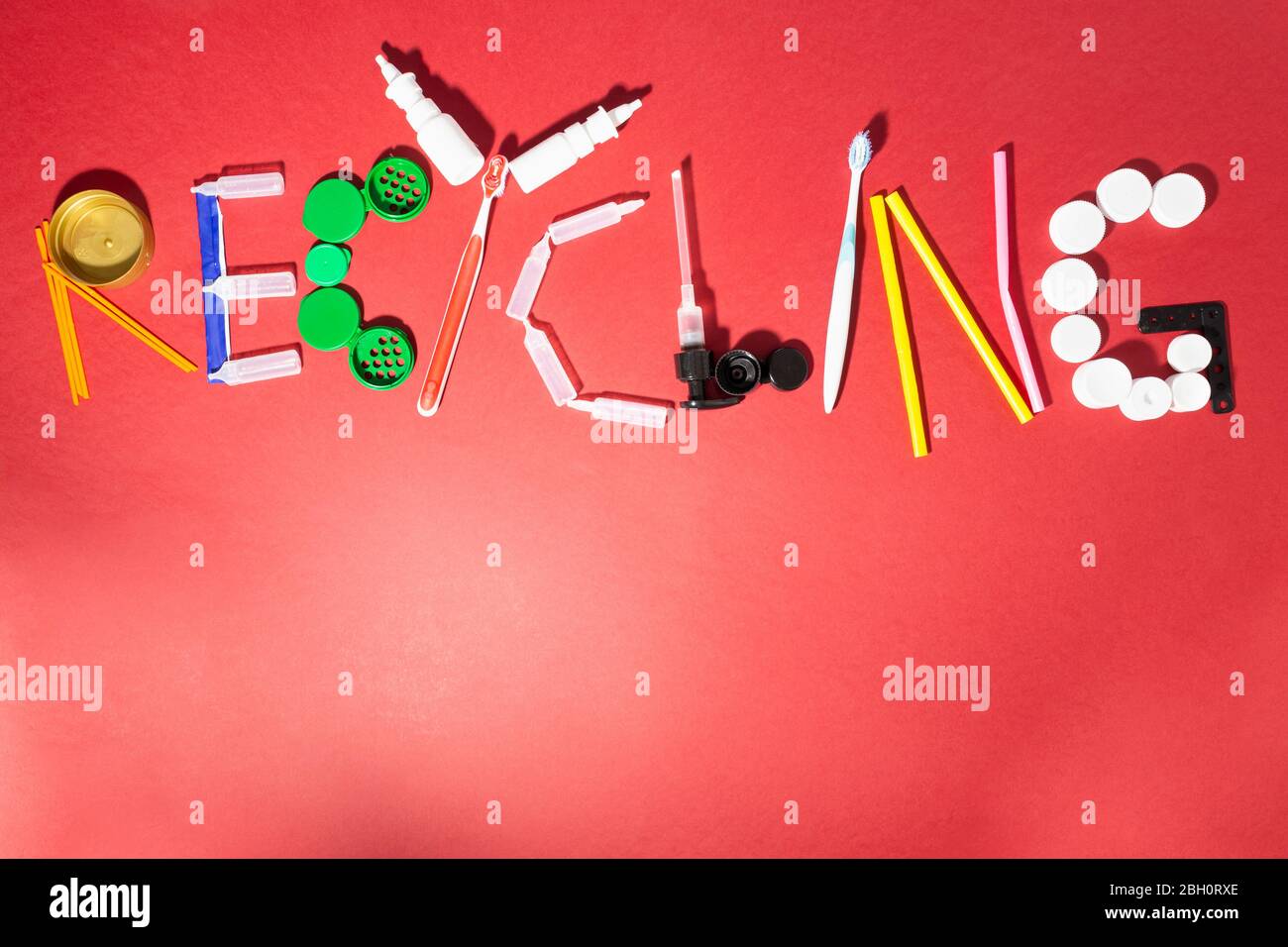 The word recycling composed with various plastic garbage items on ...