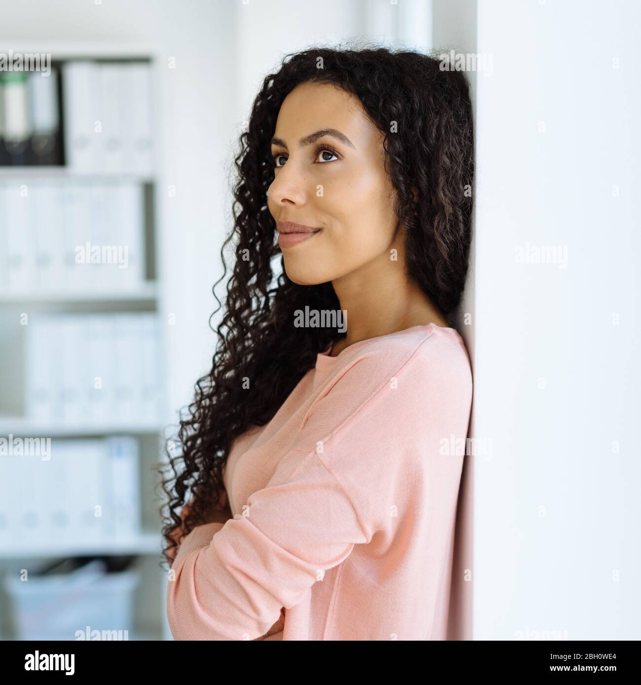 Thoughtful Serious Young African Woman Standing Leaning Against An