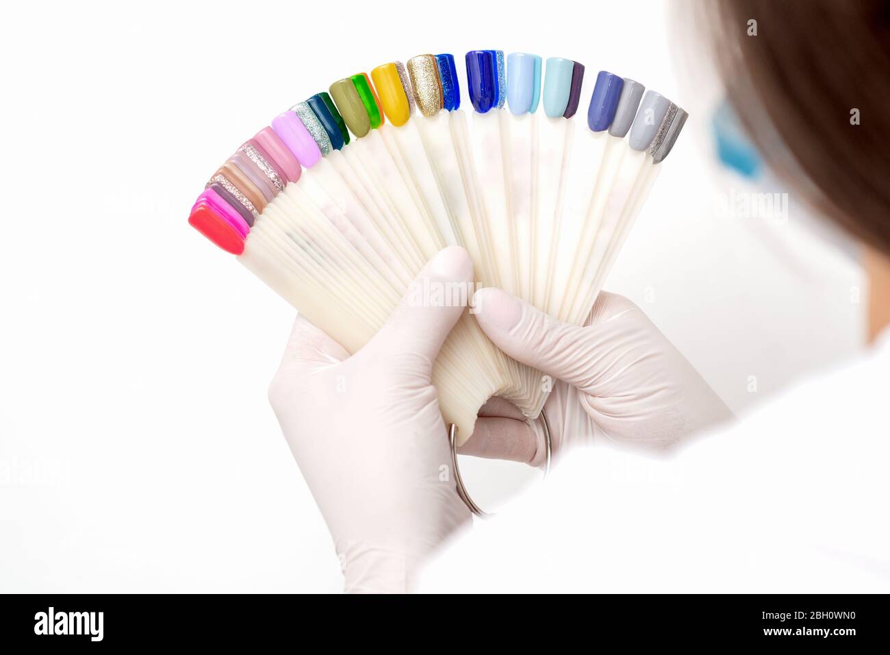 Manicurist hands are holding manicure nail color samples palette on ...