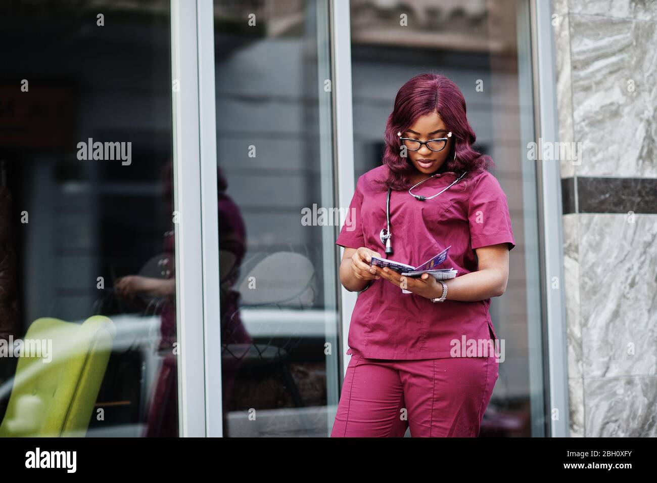 African american female doctor at red lab uniform with stethoscope ...