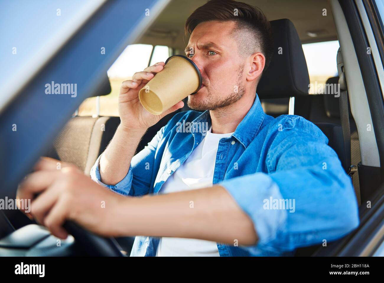 Stressed man driving a car and drinking coffee in a rush Stock Photo ...