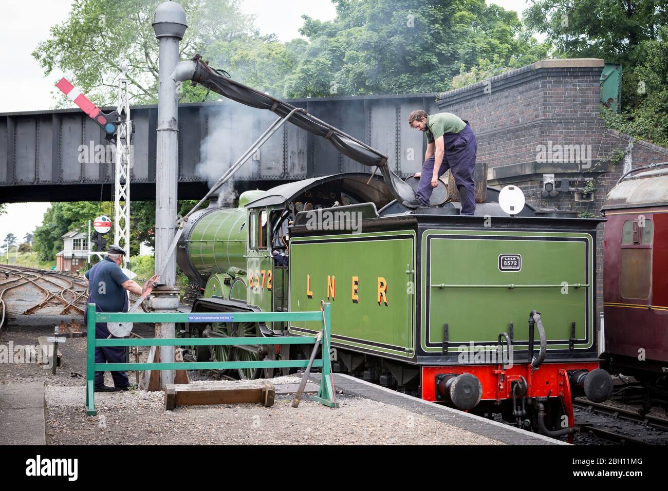 Steam Train being filled with water Stock Photo - Alamy