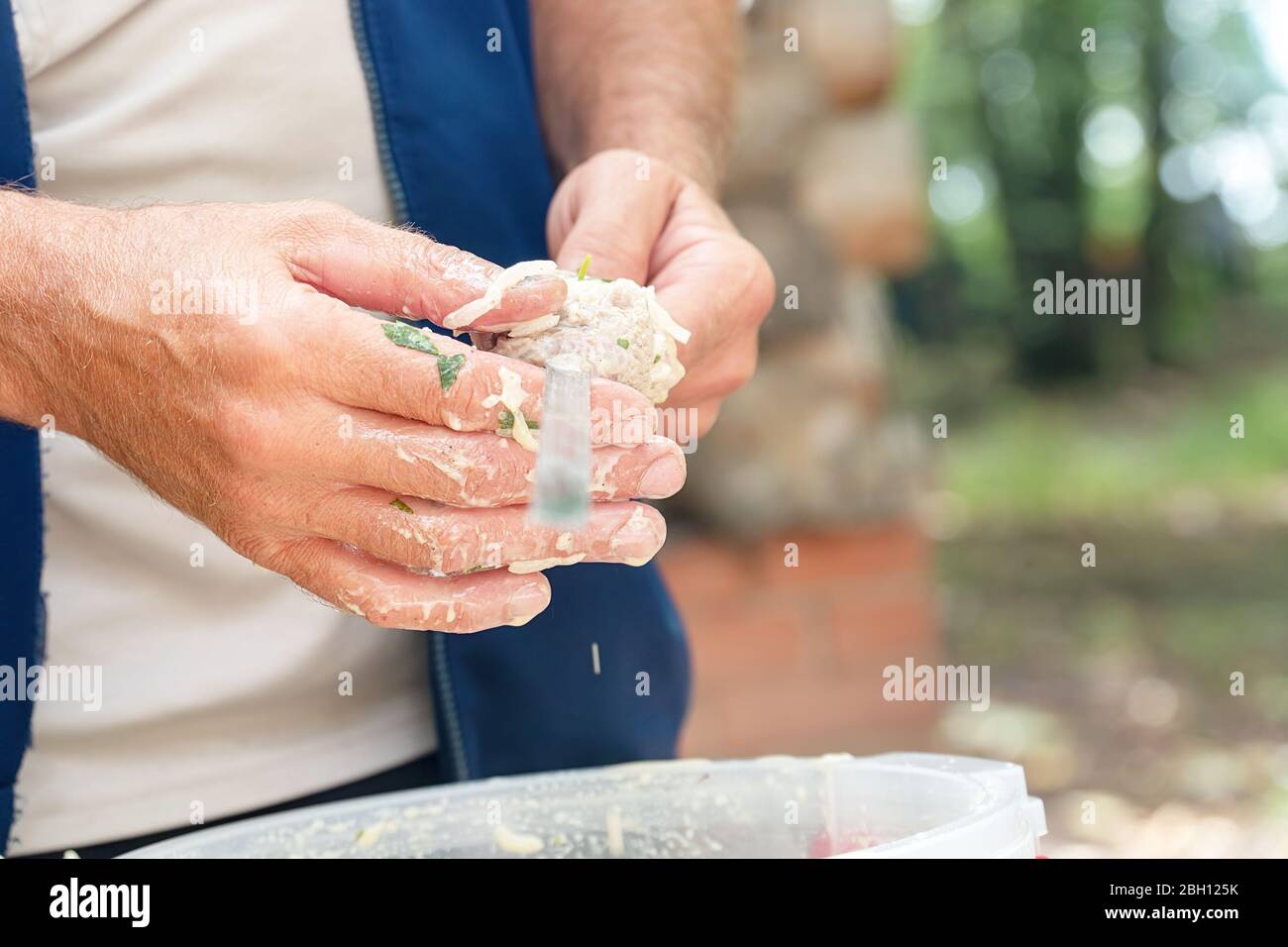 Man stringing marinated meat on a skewer for barbecue Stock Photo - Alamy