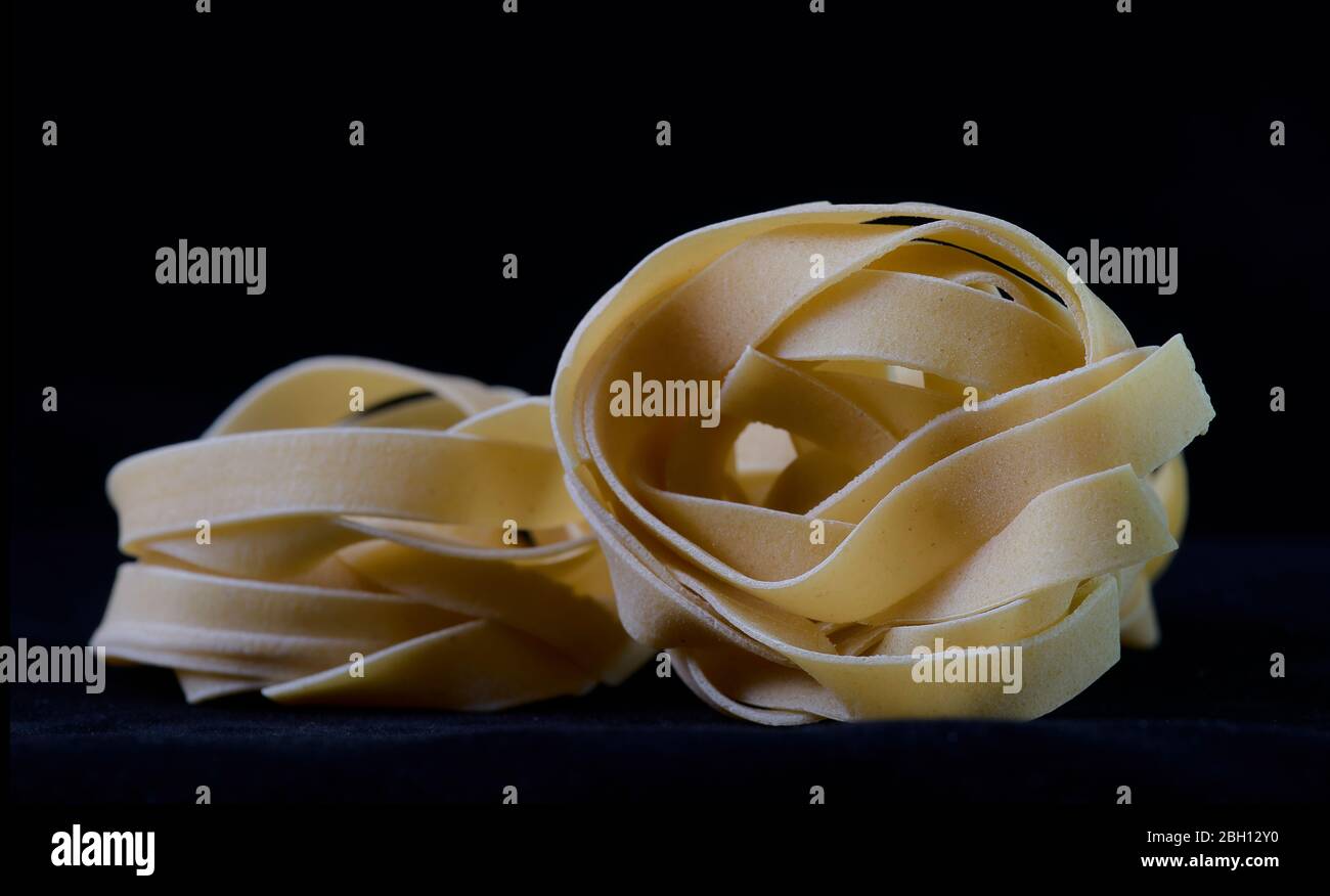 funky pasta strips on black background Stock Photo - Alamy