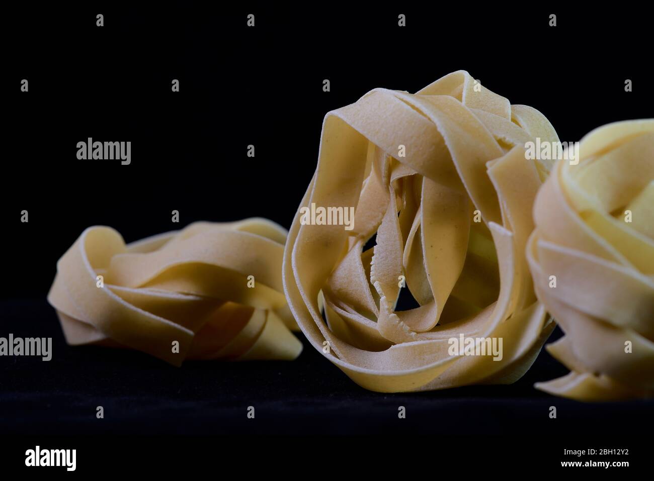 funky pasta strips on black background Stock Photo - Alamy