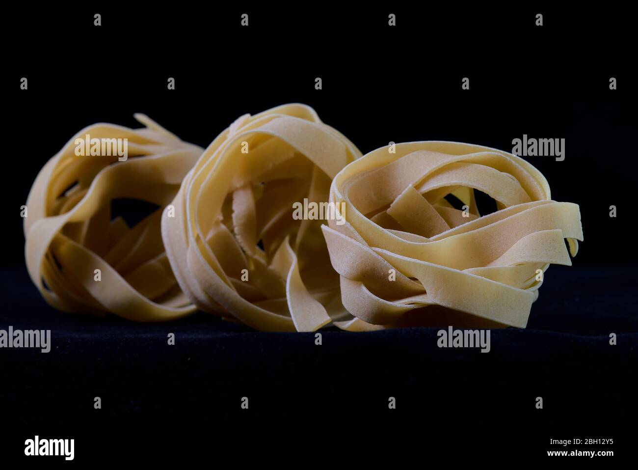 funky pasta strips on black background Stock Photo - Alamy