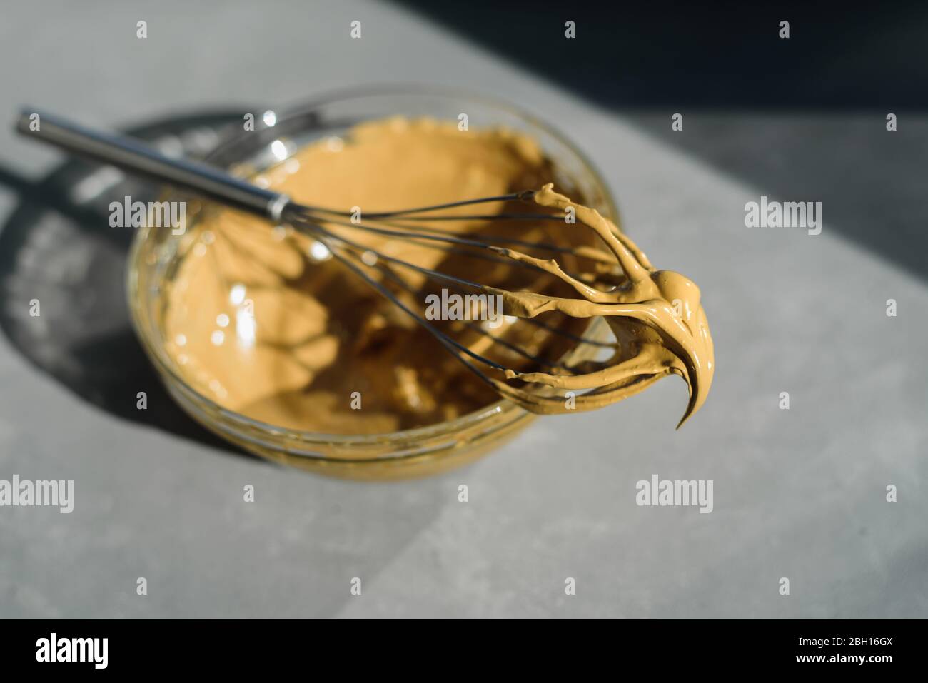 Whipping instant coffee for dalgona drink with whisk. Hard sun light ...