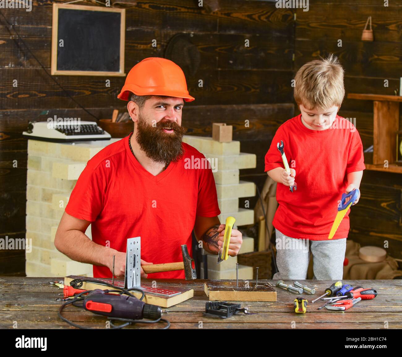Father, parent with beard in protective helmet teaching little son to ...