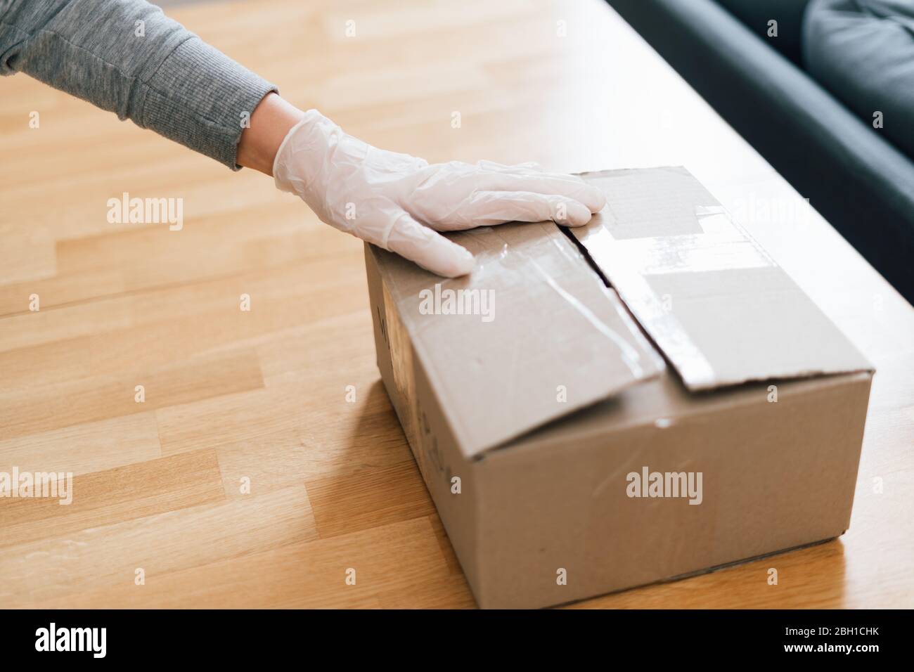 Close up of woman hands in gloves packing box with fresh fruits and ...