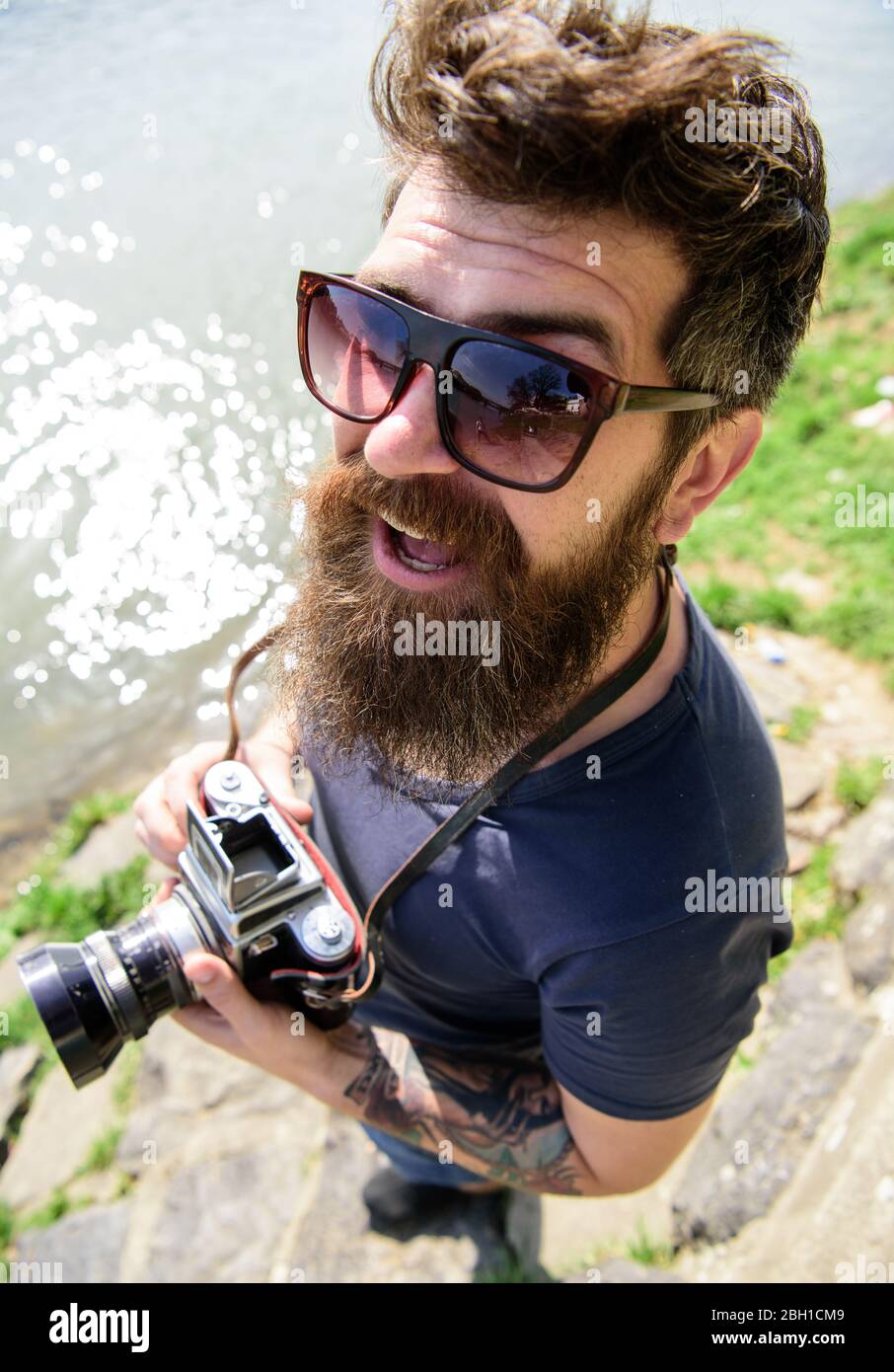 Reporter photographer concept. Man with beard and mustache wears ...