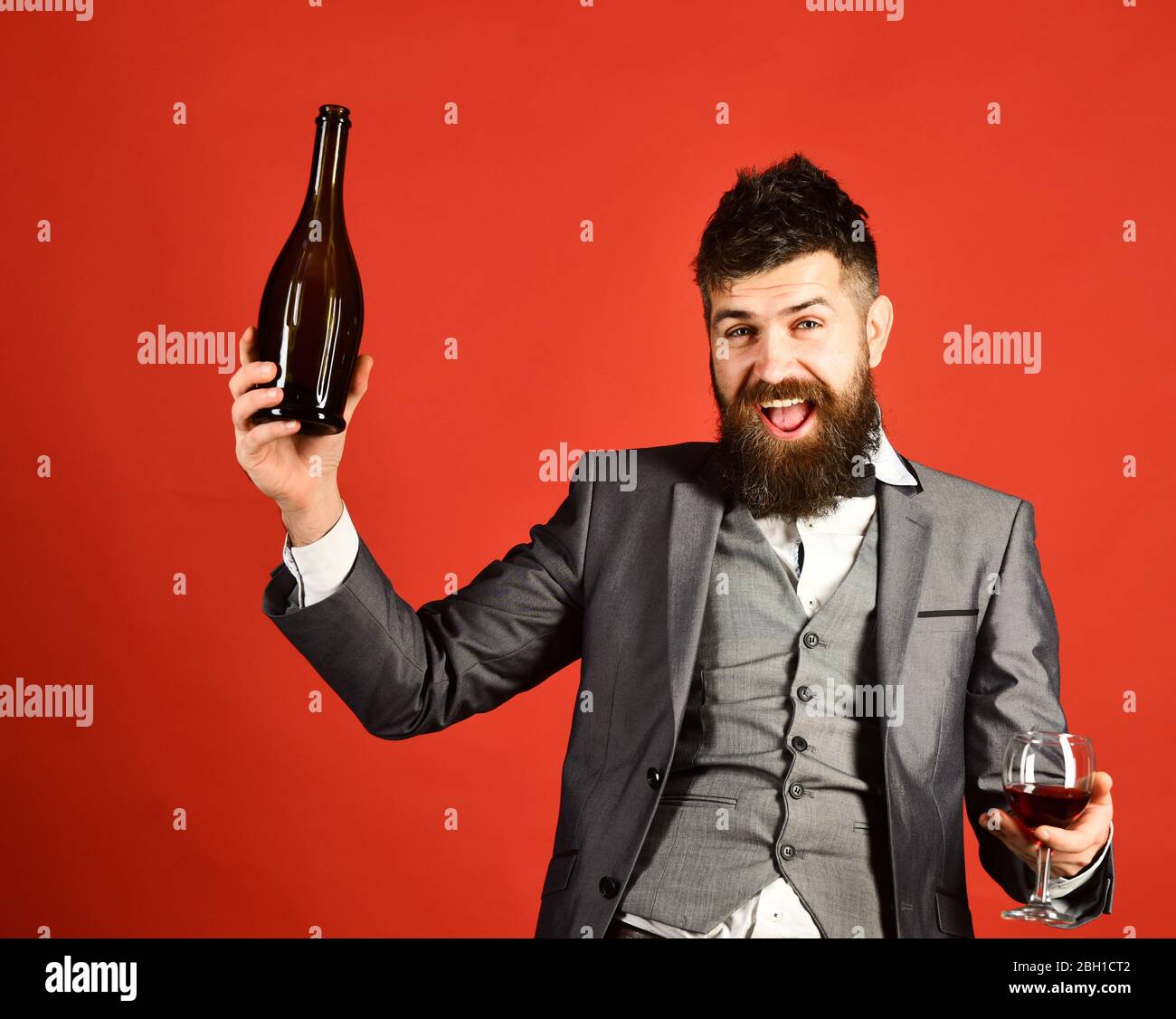 Degustator with beard and expensive alcohol on red background ...