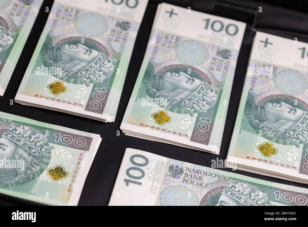 The banknotes lie in piles on a desk top during a cash financial ...