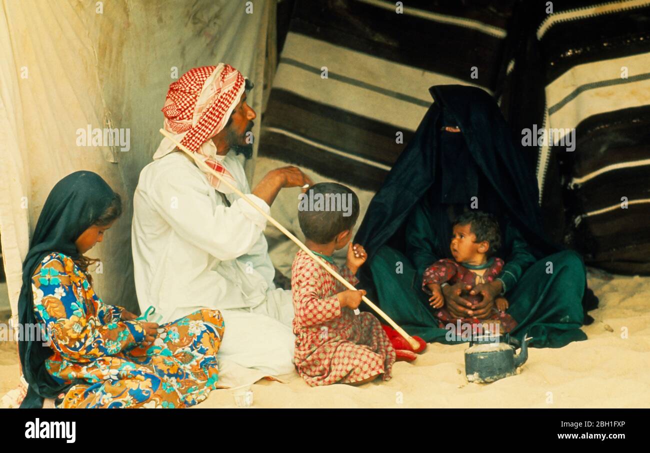 Qatar, General, Bedouin family in tent entrance with woman wearing ...