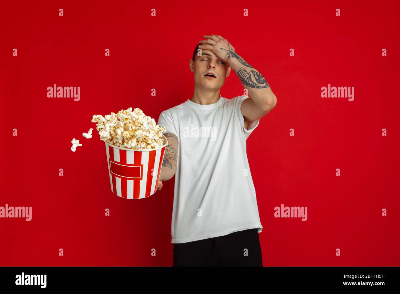 Crazy shocked, upset. Caucasian young man's portrait on red studio ...