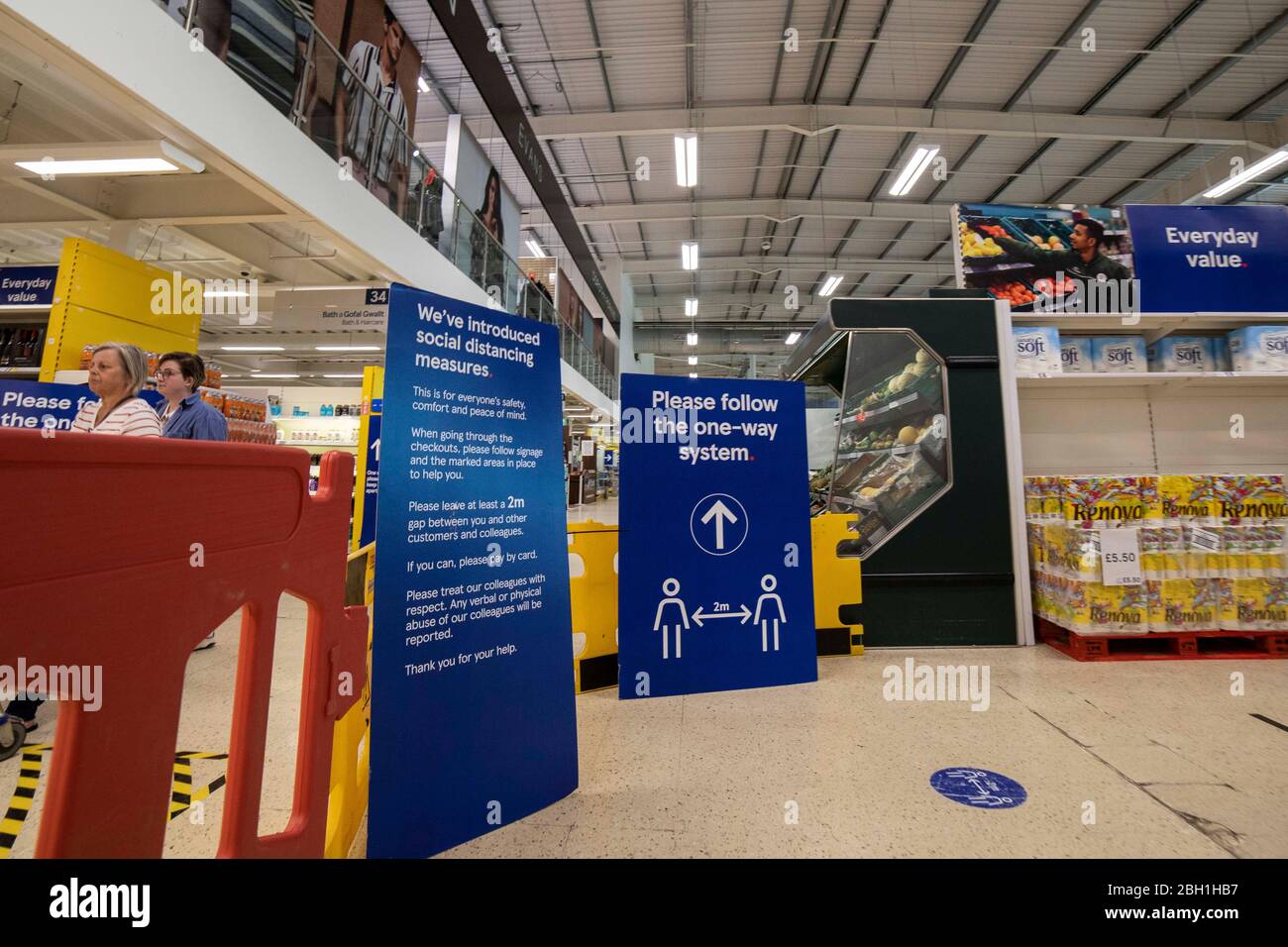 Social distancing guidelines and one-way system signage inside a Tesco ...