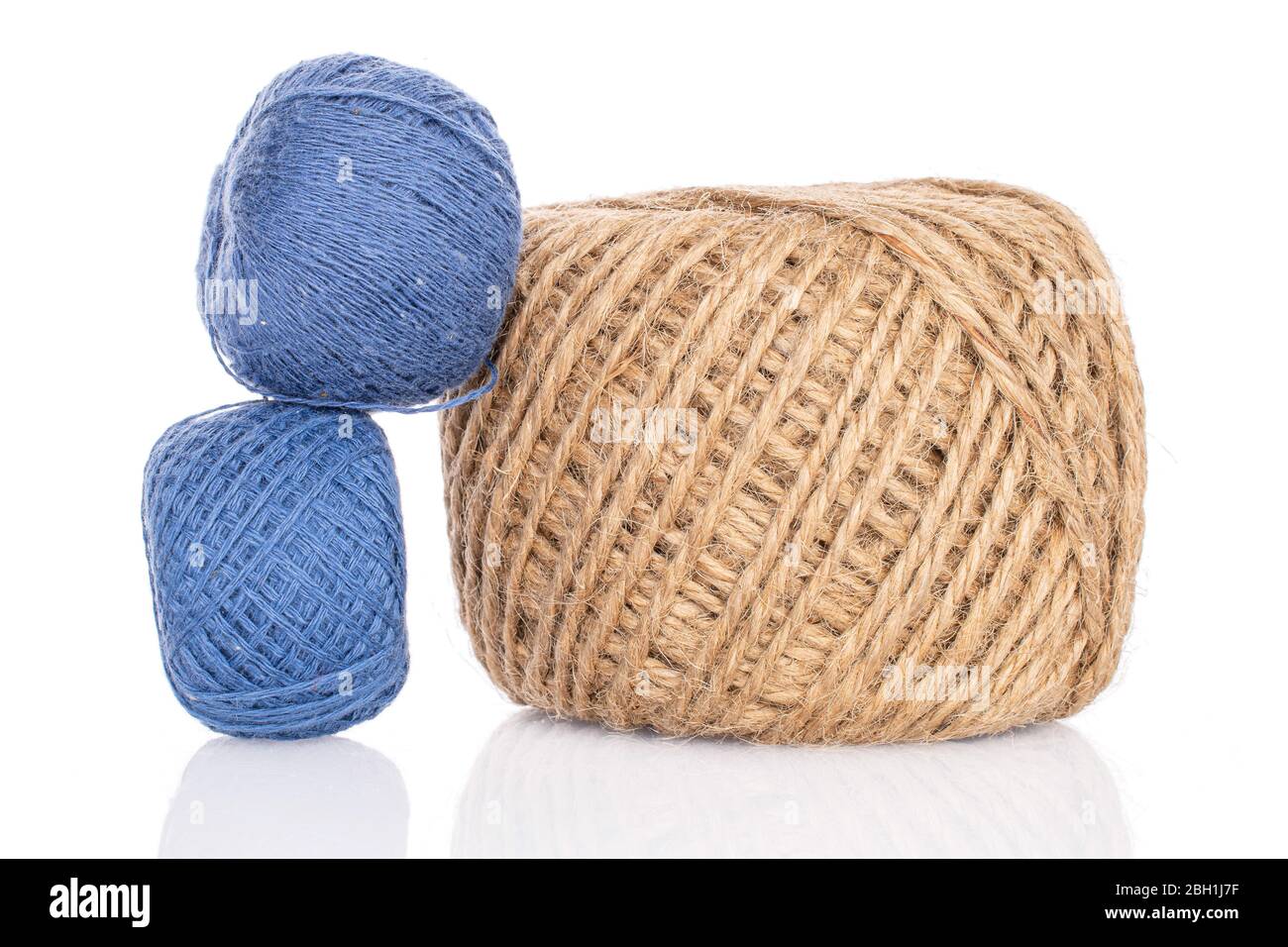 Group of three whole thread spools two blue one beige isolated on white ...