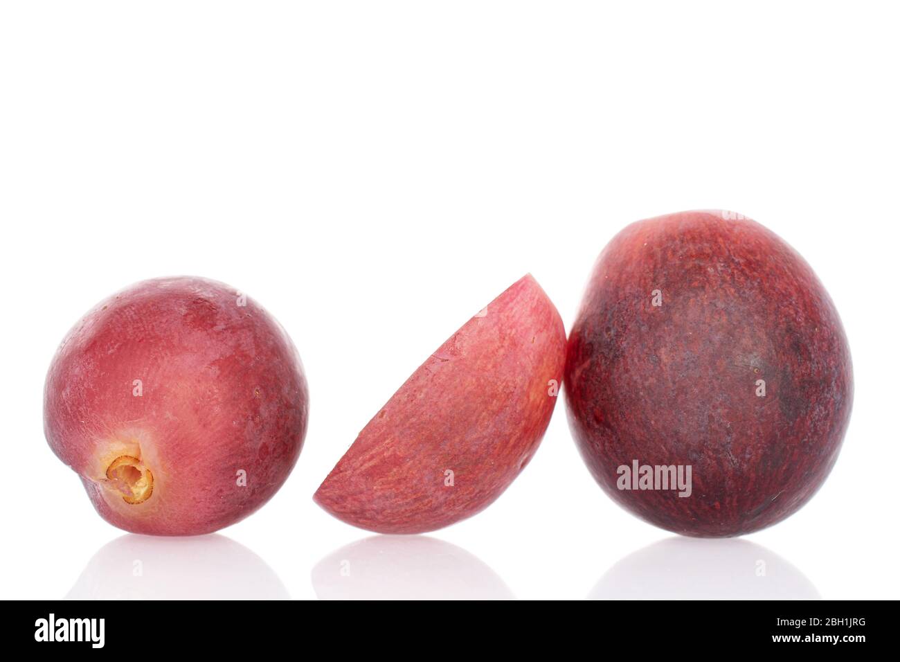Group of two whole one half of fresh red globe grape isolated on white ...