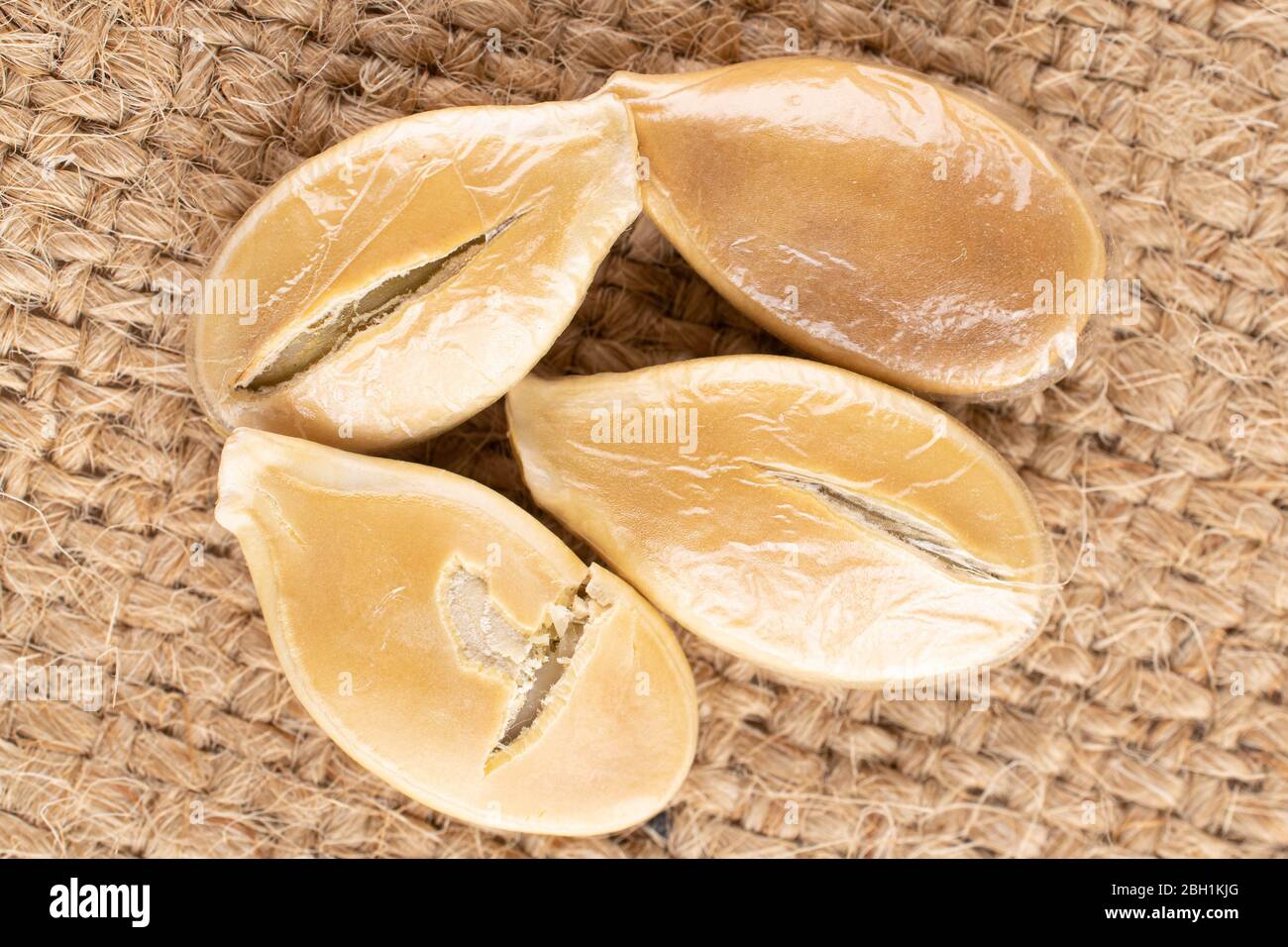 Group of four whole golden pumpkin seed on jute cloth Stock Photo - Alamy