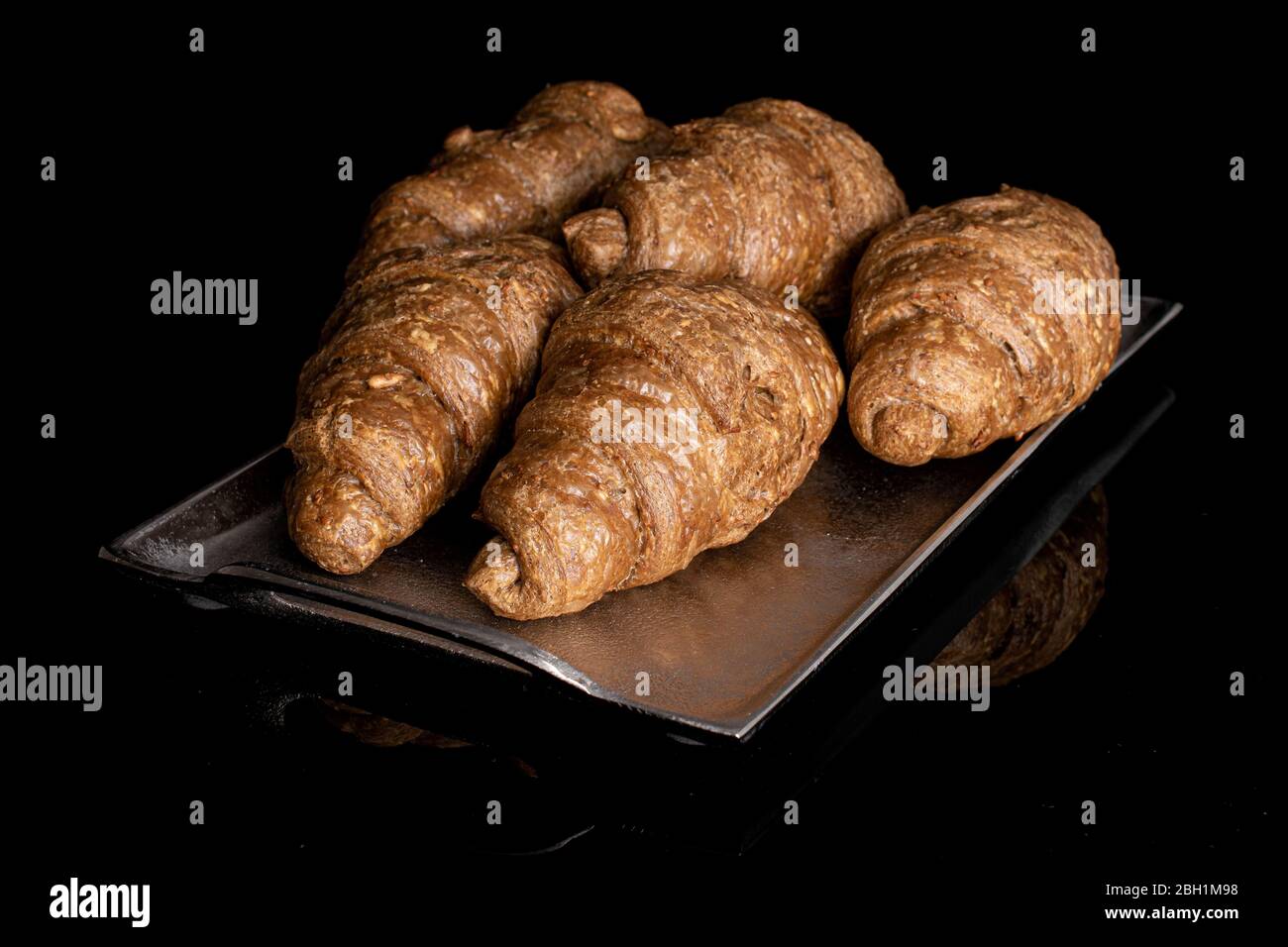 Group of five whole baked wholegrain croissant on tray isolated on ...