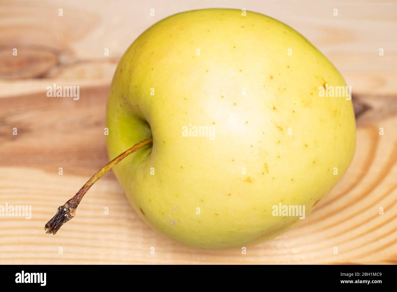 One whole green delicious apple on wood Stock Photo - Alamy