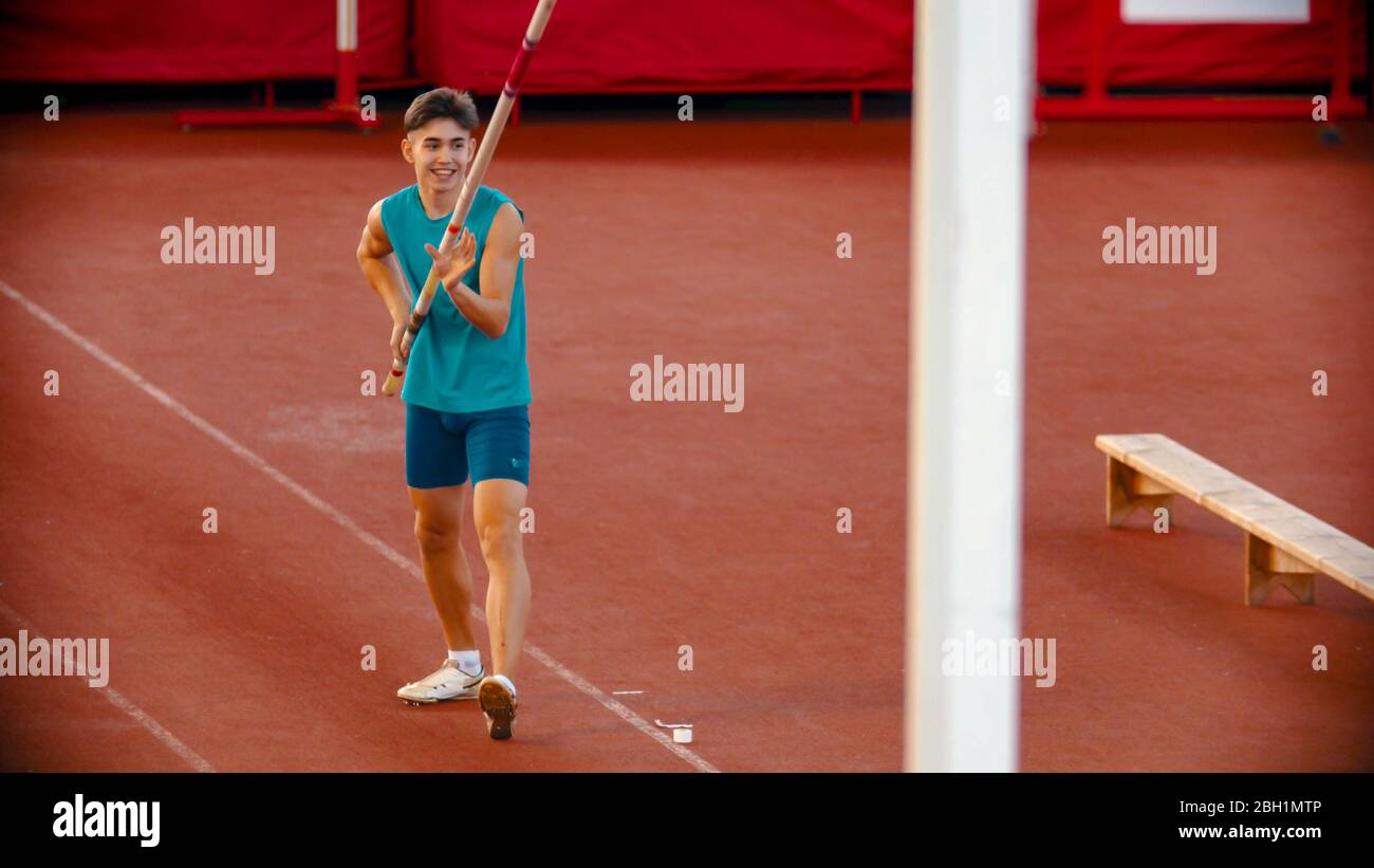 Pole vault training on the stadium - a young smiling man preparing ...