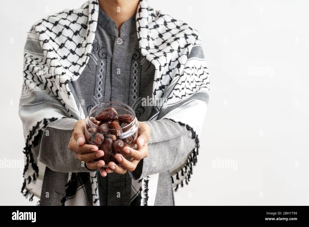 hand with a bowl of dates fruit over white background Stock Photo - Alamy