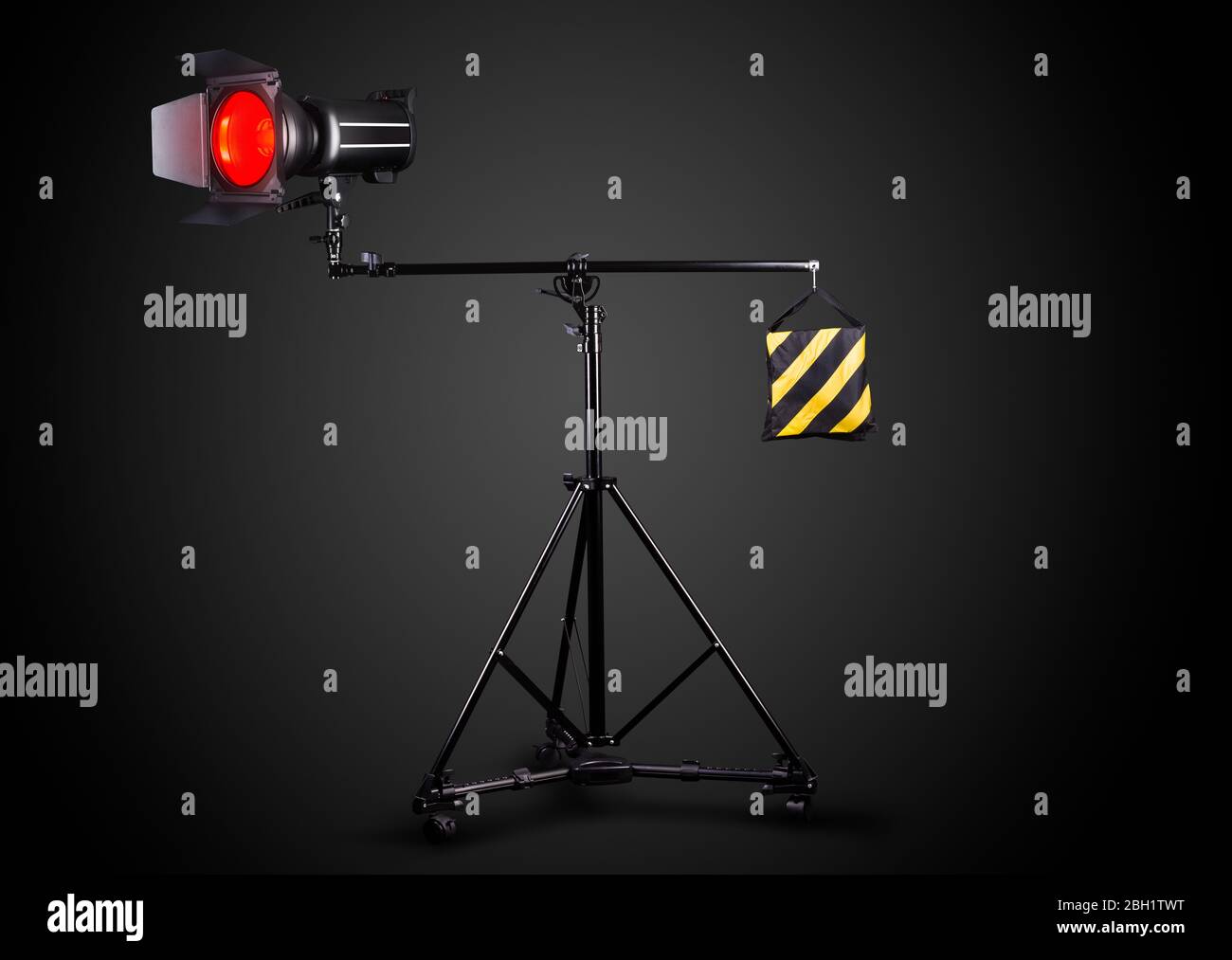 Photography studio flash on a lighting stand isolated on black ...