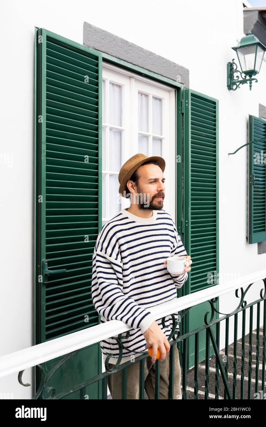 Man standing on balcony looking out Stock Photo - Alamy